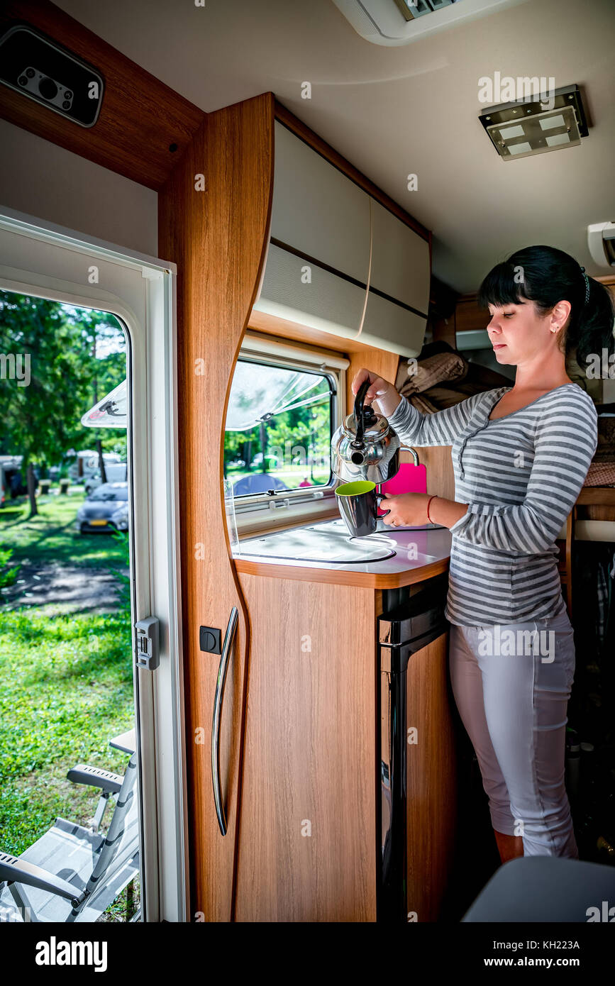 Woman cooking in camper, motorhome interior. Family vacation travel ...