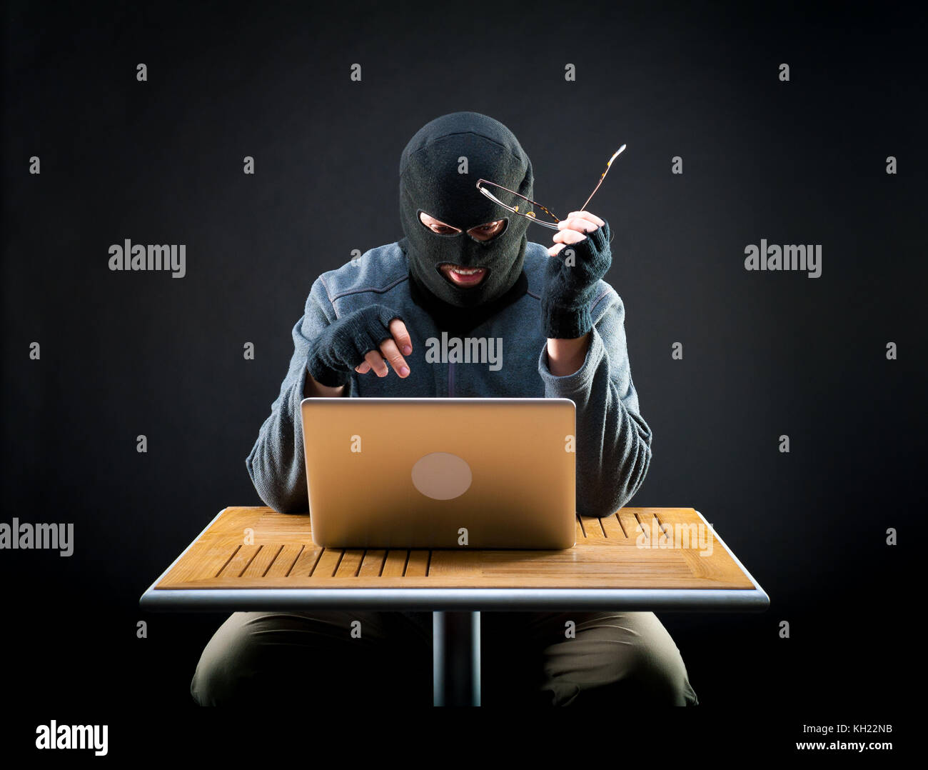 Hacker at work, holding glasses in the hand Stock Photo - Alamy