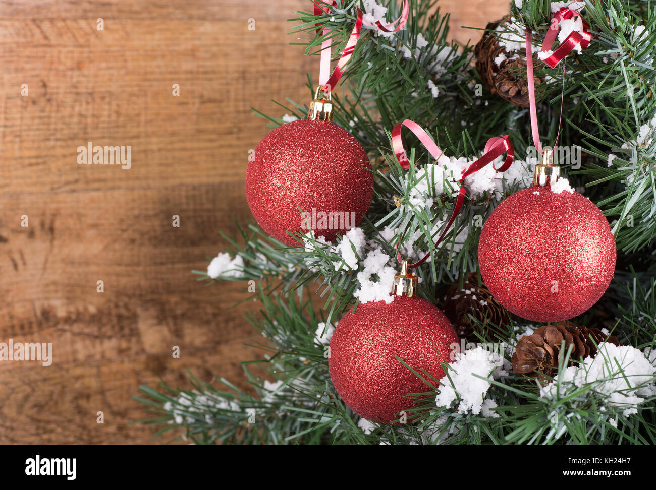 Red Christmas ornaments hanging on a tree with a wood background Stock ...