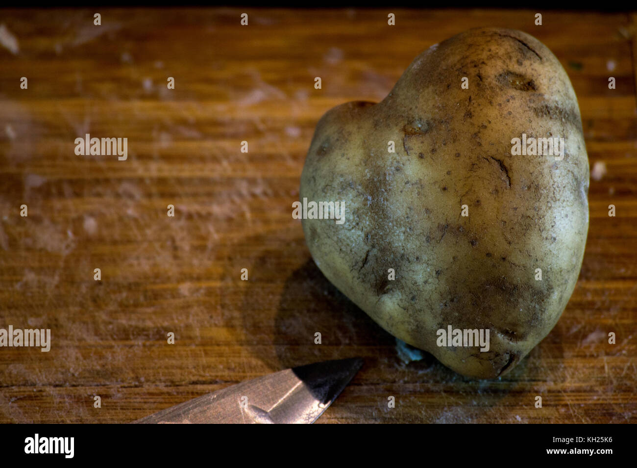 Heart shape potato with knife Stock Photo - Alamy