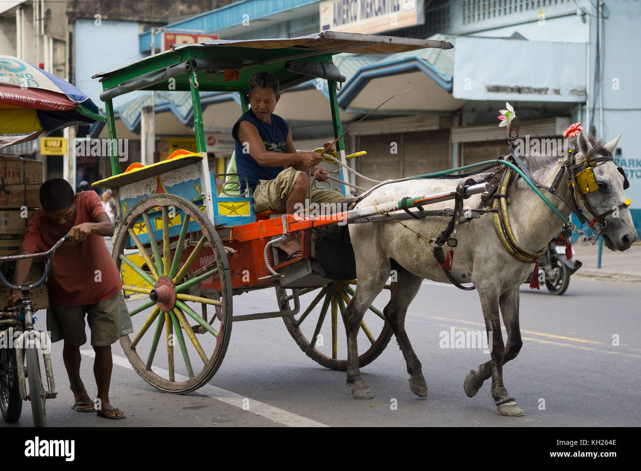 A horse drawn carriage known as a Kalesa being driven in downtown Cebu ...