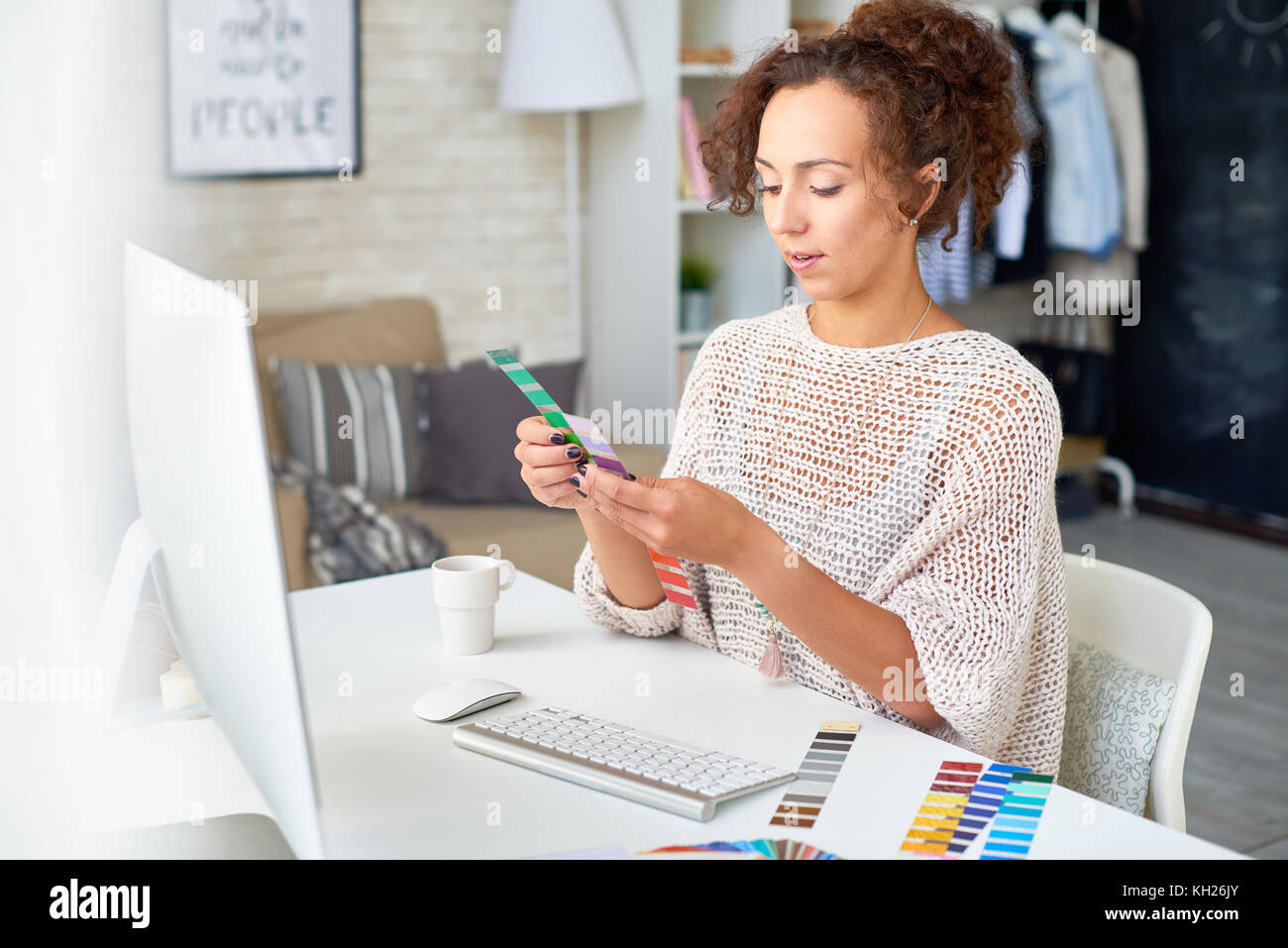 Portrait of creative young woman looking at color swatches choosing ...