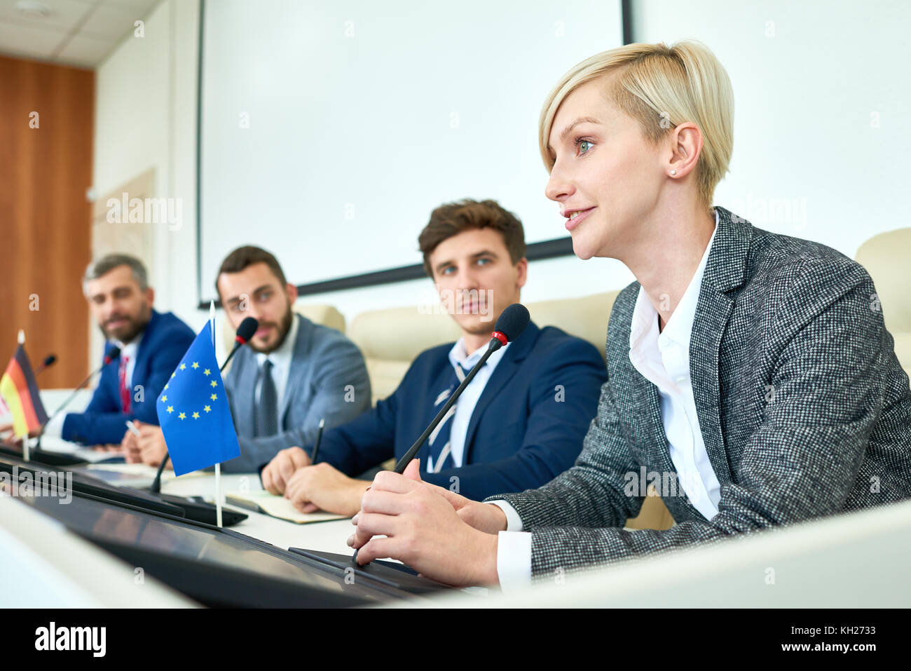 Portrait of several business people sitting in row participating in ...