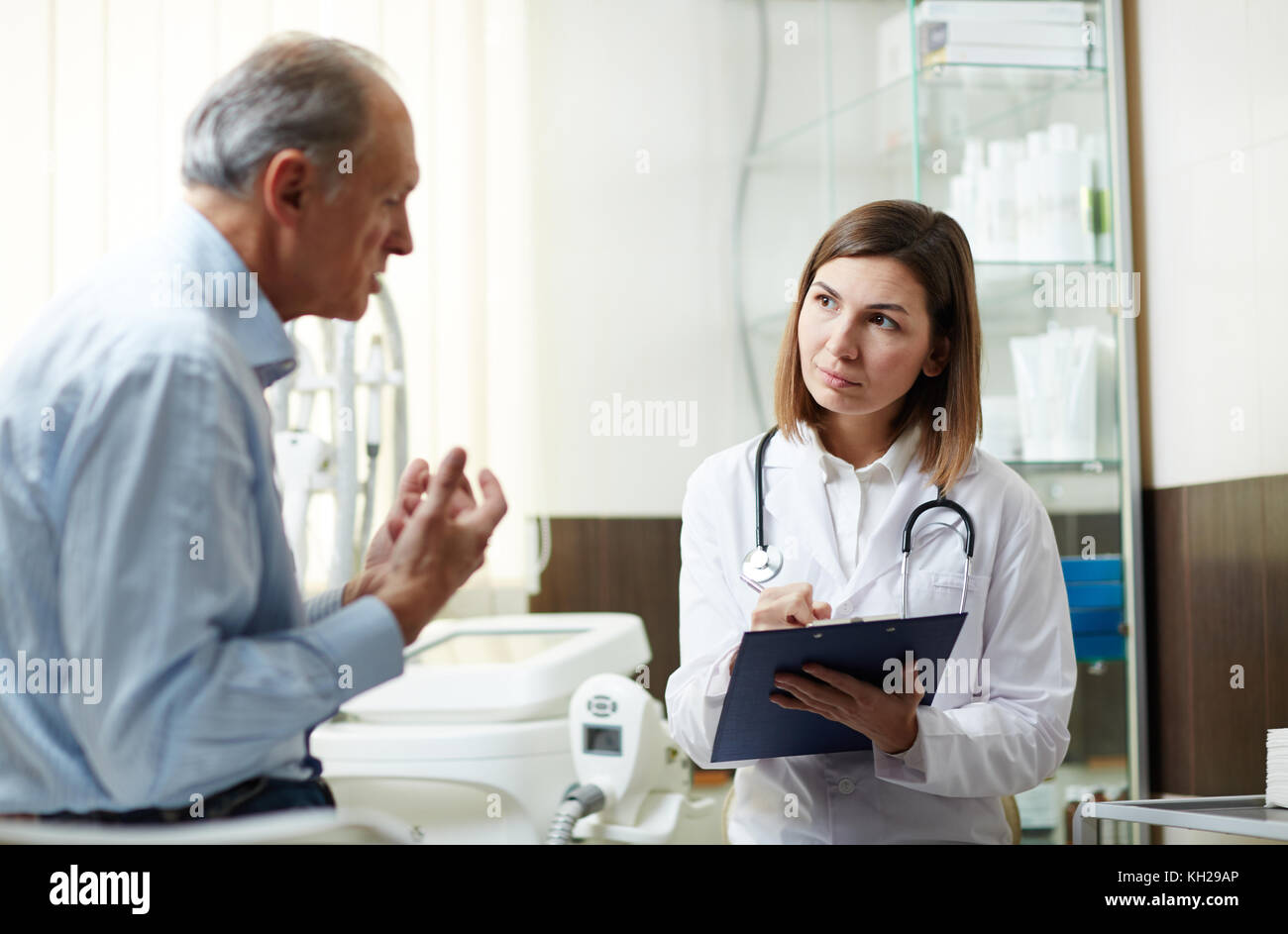 Senior patient explaining his problem to doctor during appointment ...