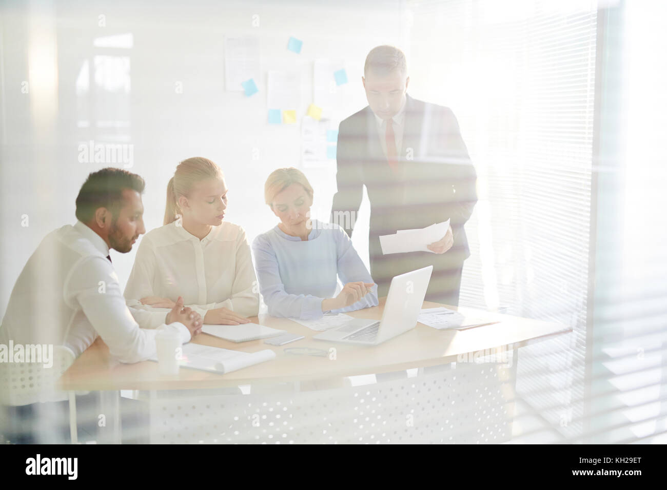 Group of analysts having discussion of online statistics in boardroom ...