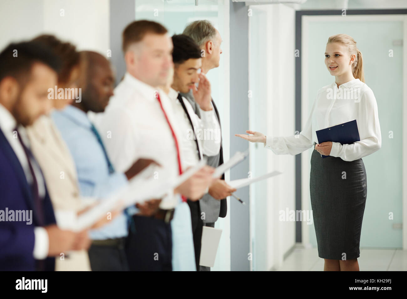 Young secretary inviting next candidate for interview to boardroom ...
