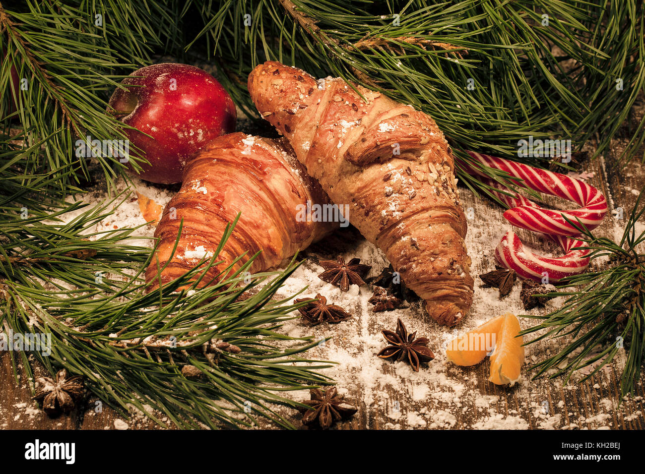 Christmas still life with sweets, croissant and apple under the ...