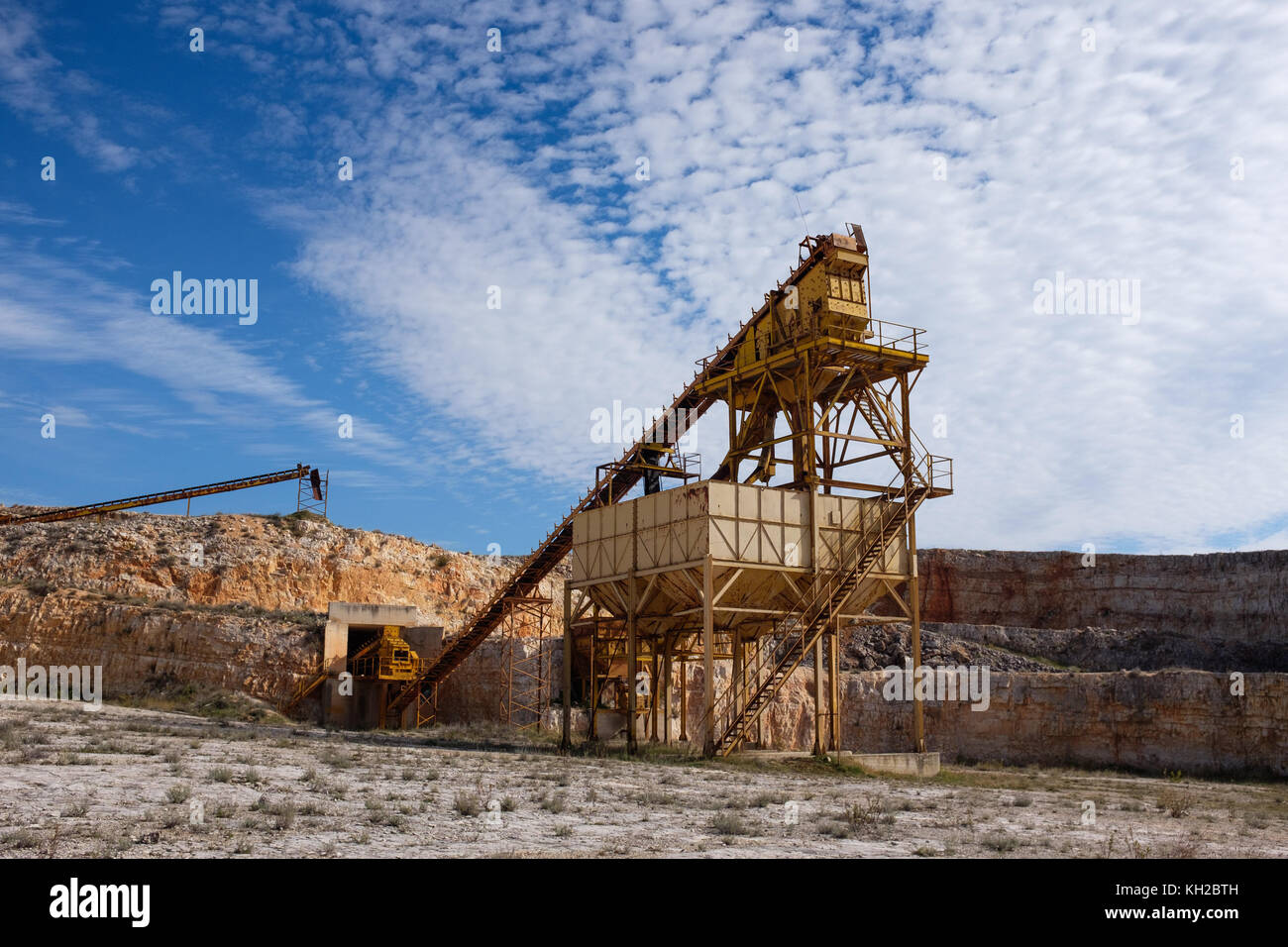 Former stone quarry with abandoned crusher and conveyor machines ...