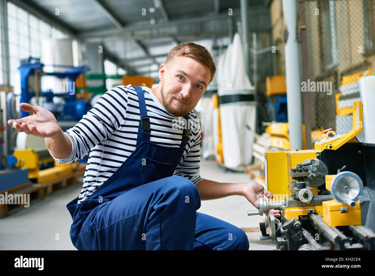 Portrait of confused repairman looking at camera in surprise while ...