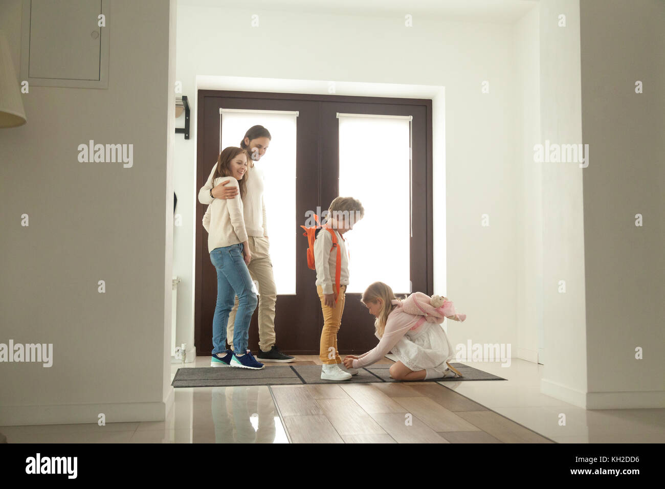 Little sister helping brother to tie shoes, girl fasten shoelaces of ...
