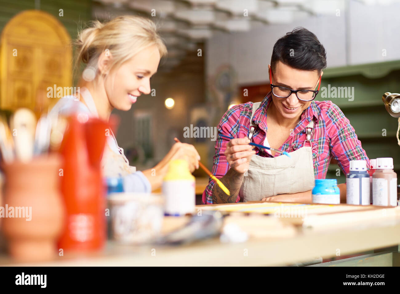 Portrait of two modern female artists enjoying work together in art ...