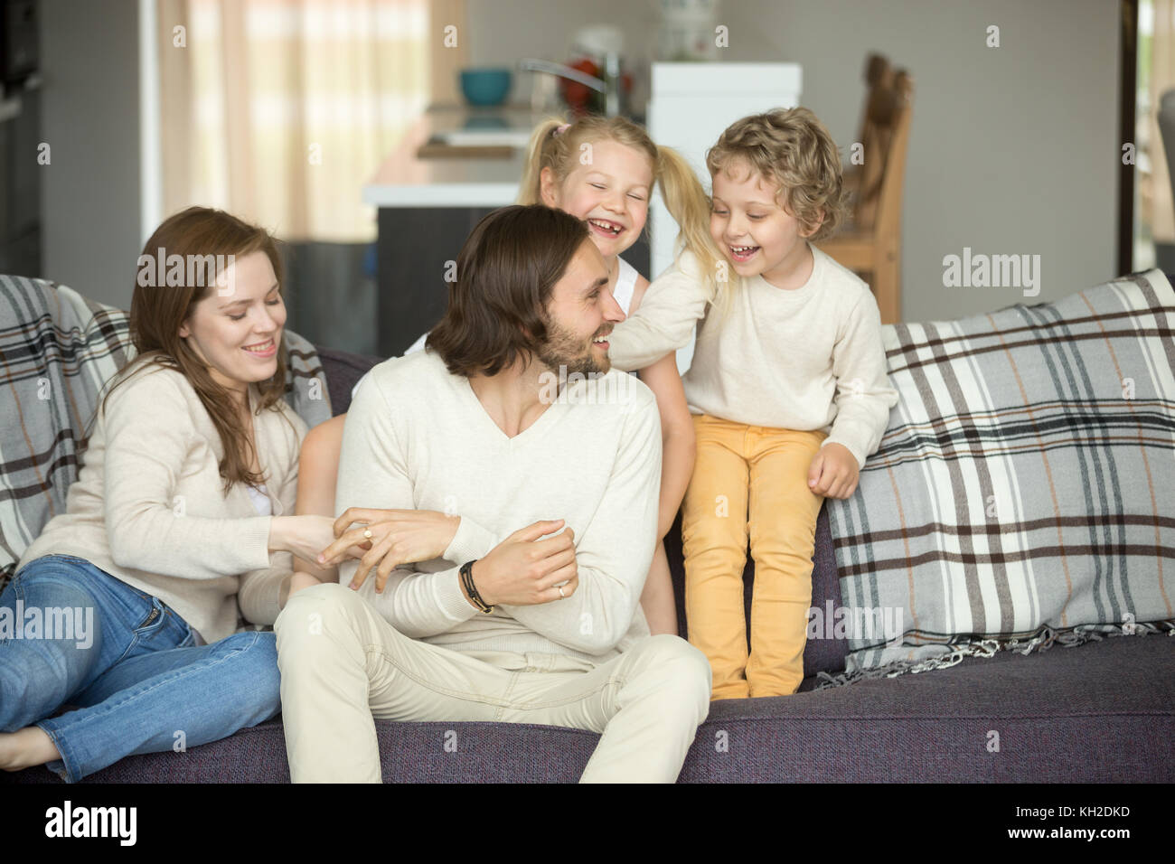 Cozy warm loving caring family of four at home together, happy parents ...