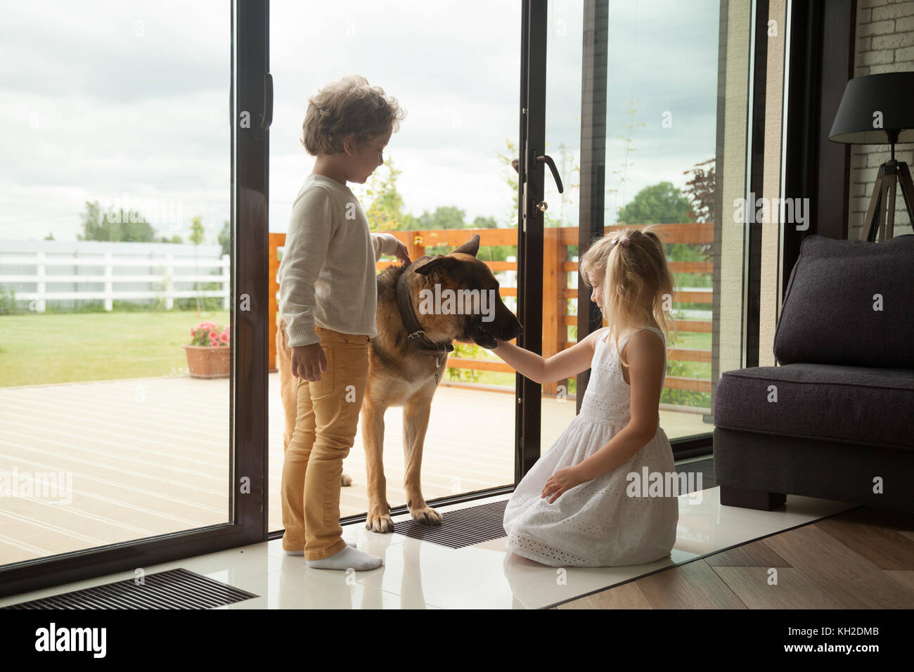 Children caressing watch dog protecting home, kids playing with big pet ...