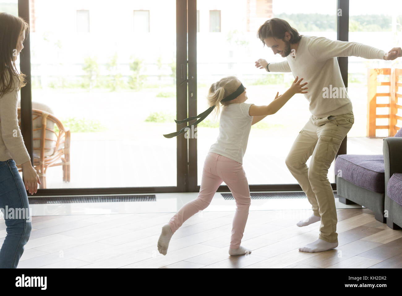Little girl catching father playing hide and seek, preschool ...