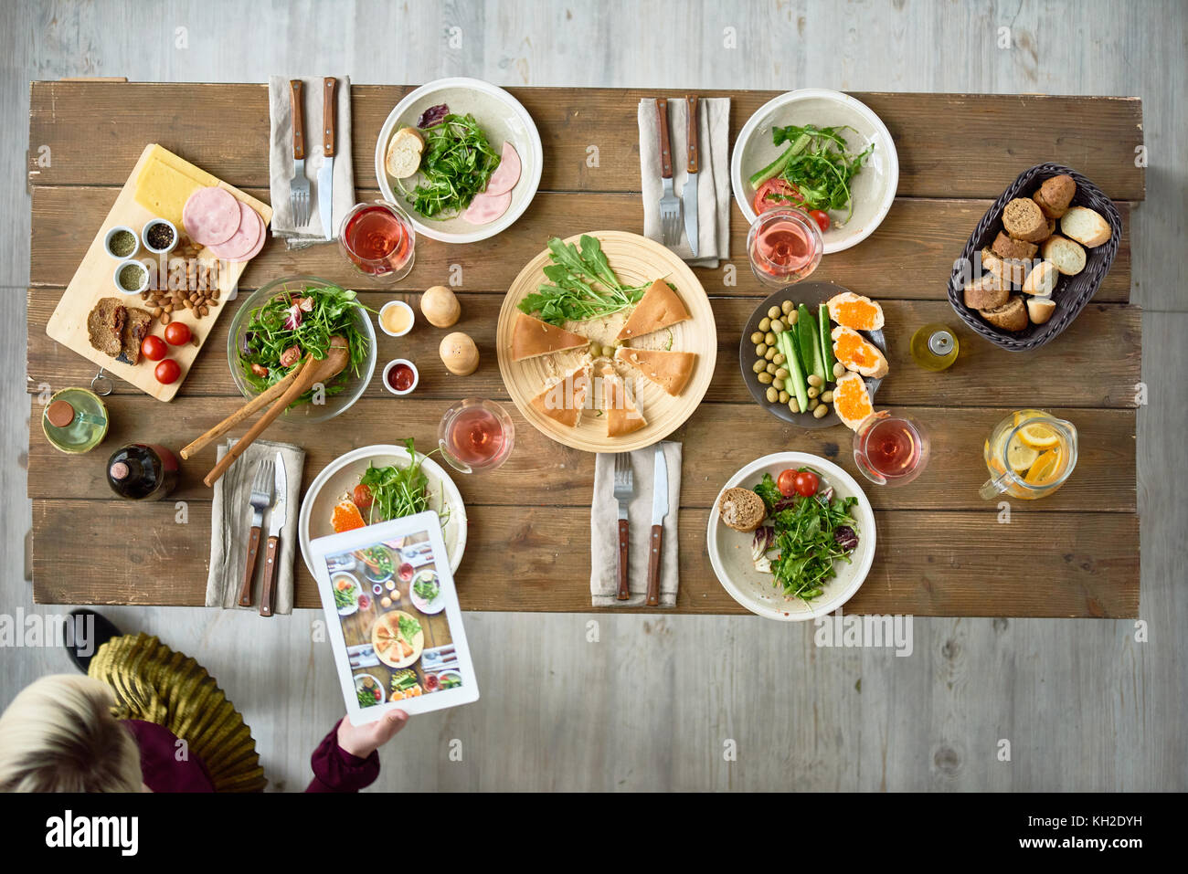 Above view of wooden dinner table with half-eaten dishes left on it ...