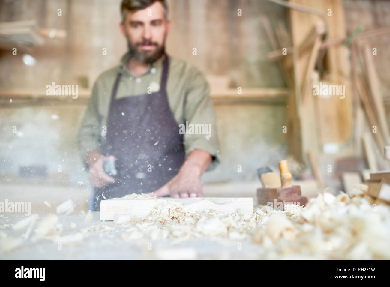 Portrait of skilled bearded carpenter making furniture in modern ...