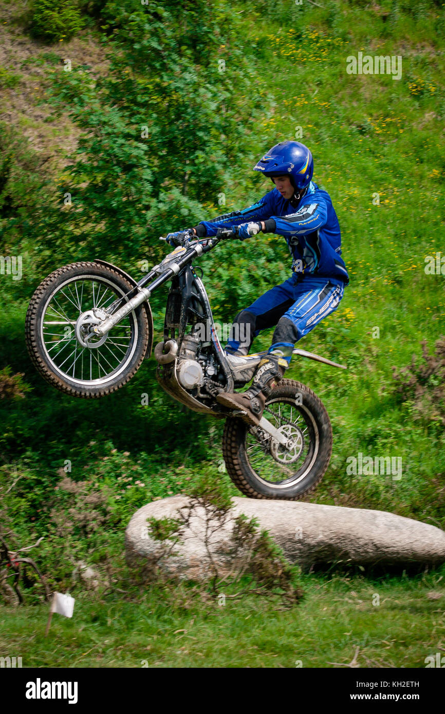 Motorcross bike rider on a cross trail showing of skills climbing rocks ...