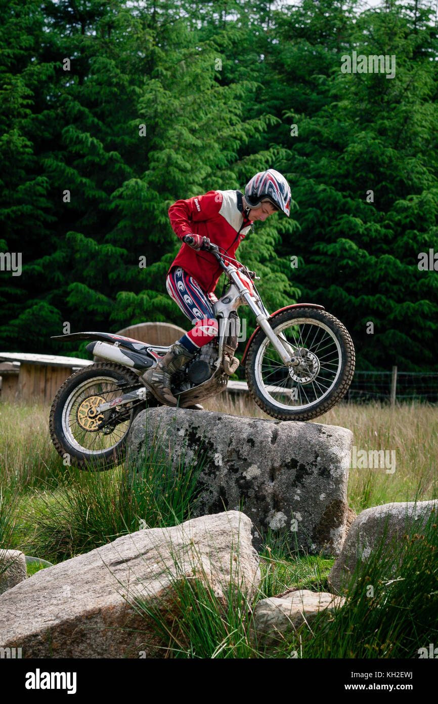 Motorcross bike rider on a cross trail showing of skills climbing rocks ...