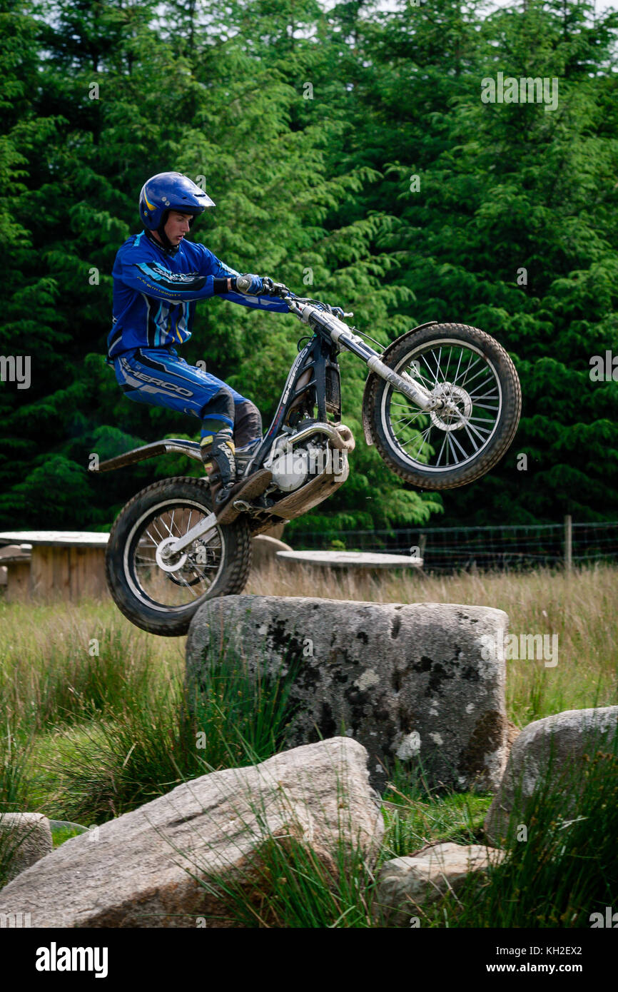 Motorcross bike rider on a cross trail showing of skills climbing rocks ...