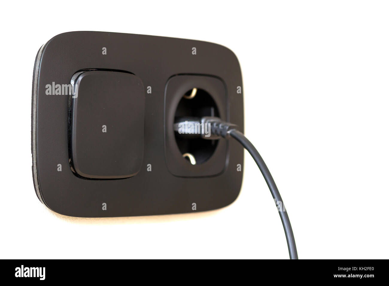 Black power cord cable plugged into european wall outlet on white ...