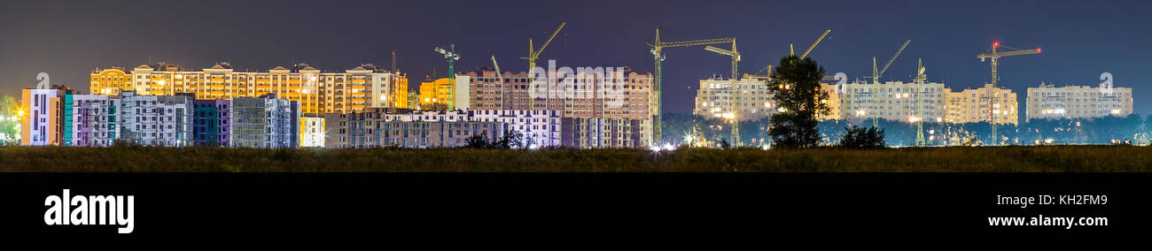 Panorama night view of many building cranes at construction site of new ...
