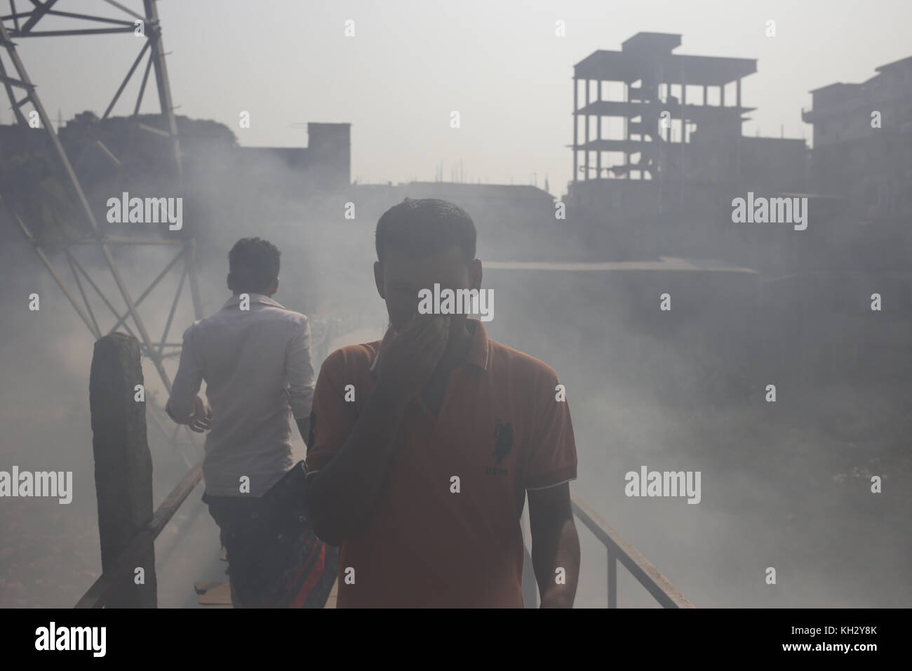 Dhaka, Bangladesh. 13th Nov, 2017. People walks beside waste burning ...