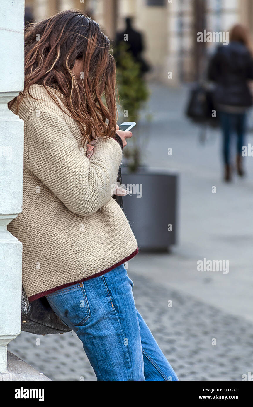 Woman with phone in hand. Phone texting. Side view. Real people ...