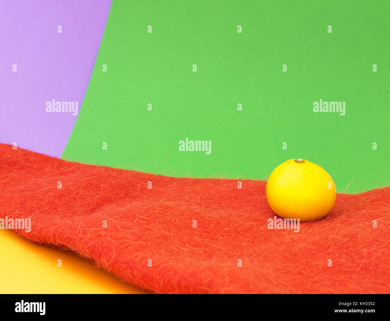One orange on colorful red green backgrounds Stock Photo - Alamy