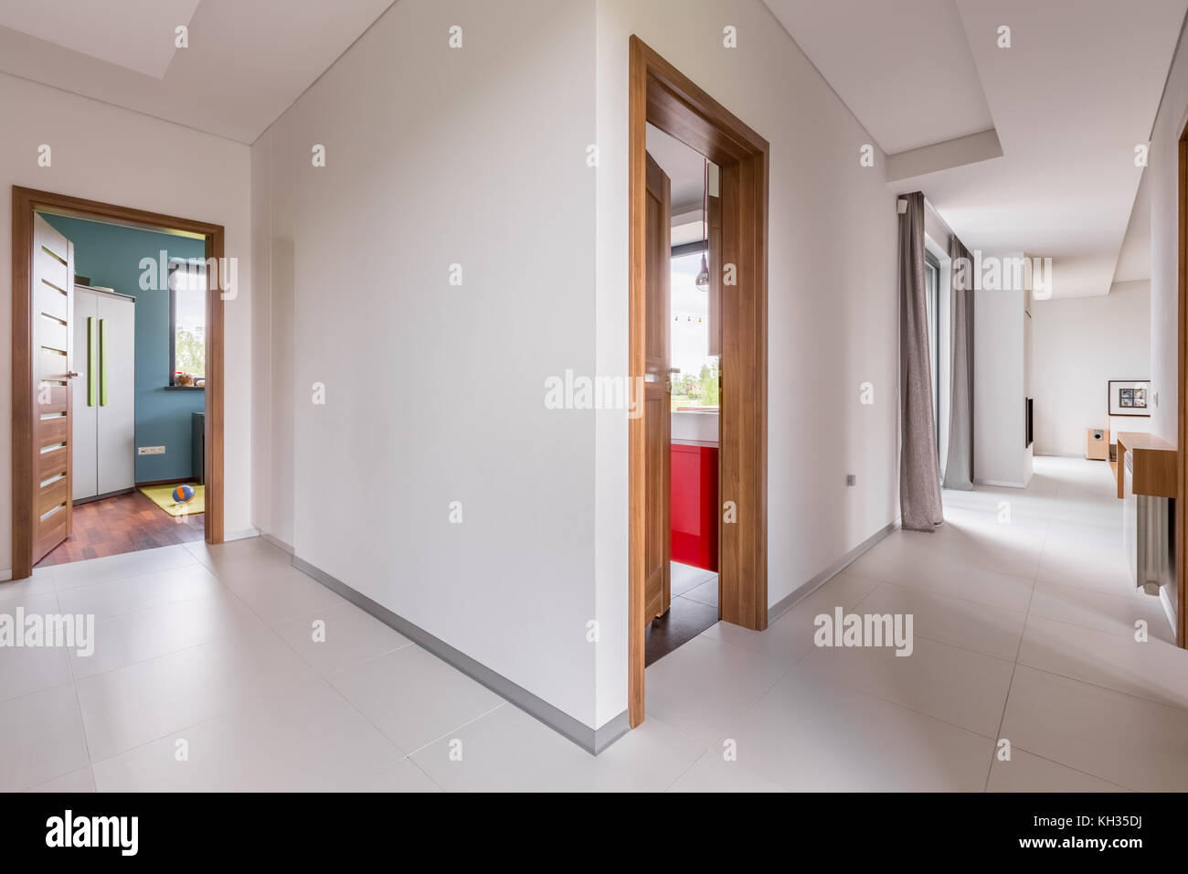 Villa interior with white corridor and wooden door Stock Photo - Alamy