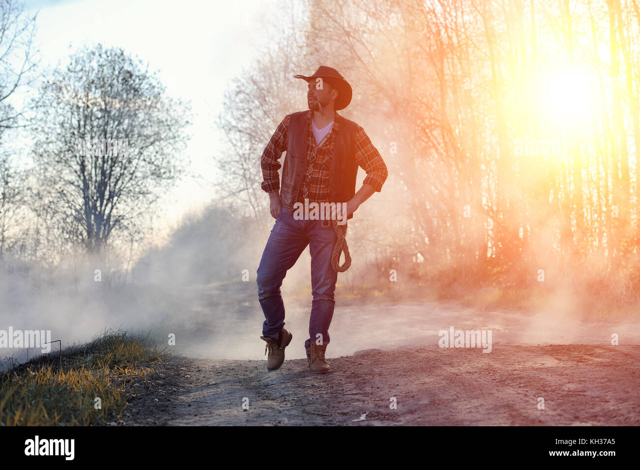 A man is wearing a cowboy hat and a loso in the field. American Stock ...