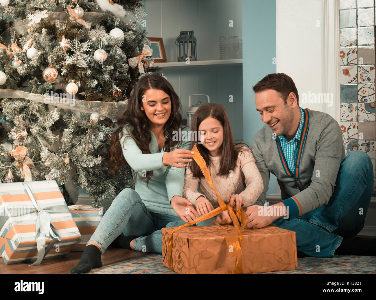 Happy family gather near Christmas tree with presents Stock Photo - Alamy