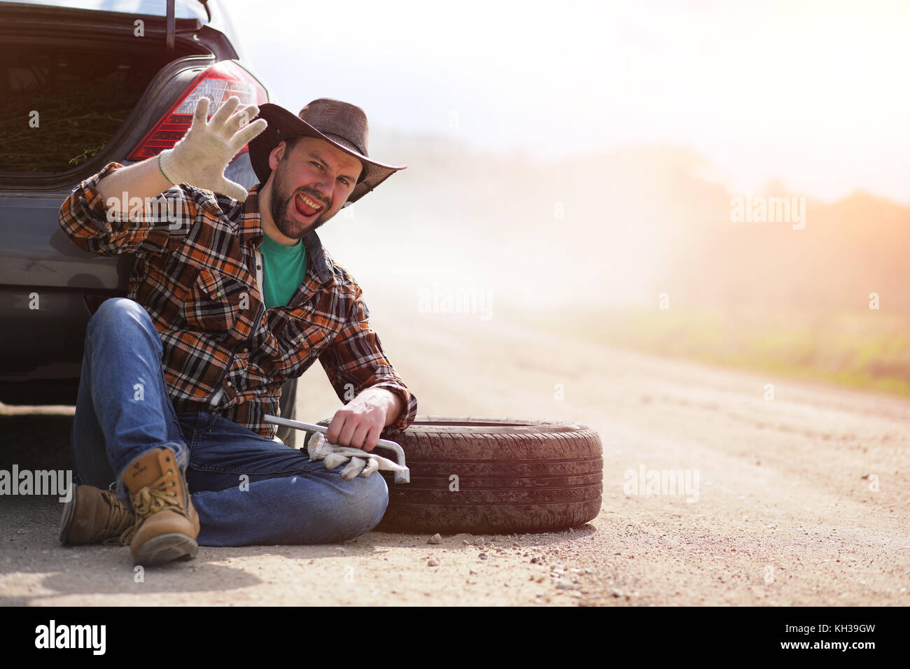 Man is sitting on the road by the car Stock Photo - Alamy