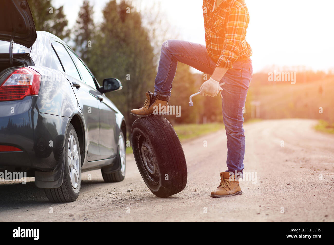 Man is sitting on the road by the car Stock Photo - Alamy