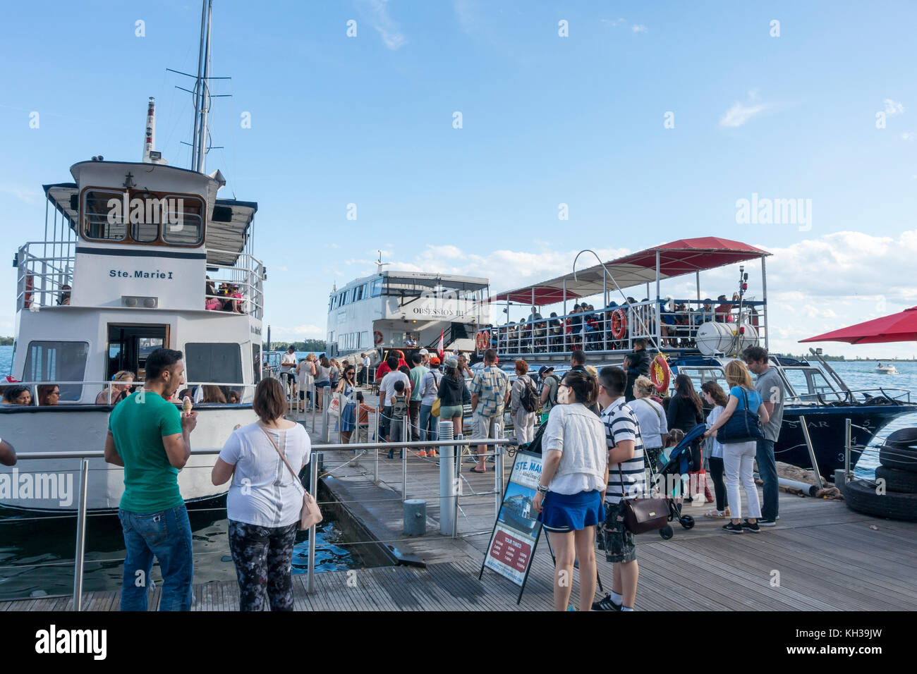 Tourists line up to board cruise boats at Toronto's popular ...