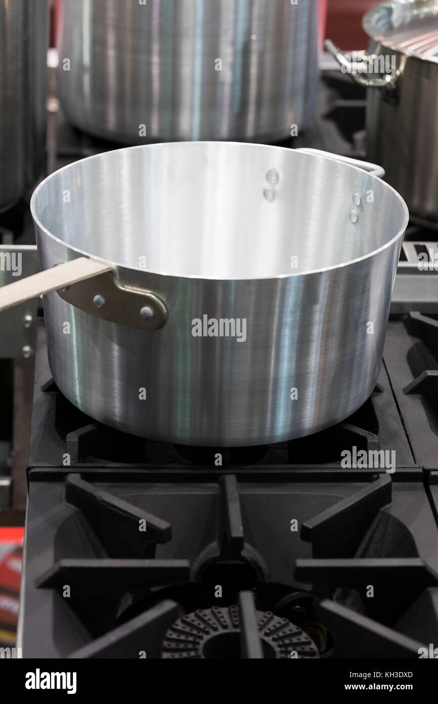 Metal stainless steel pan on a kitchen stove Stock Photo - Alamy