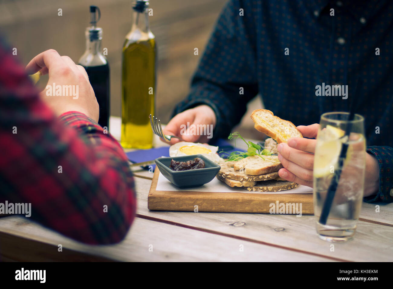 Two people eating food outside at bar Stock Photo - Alamy