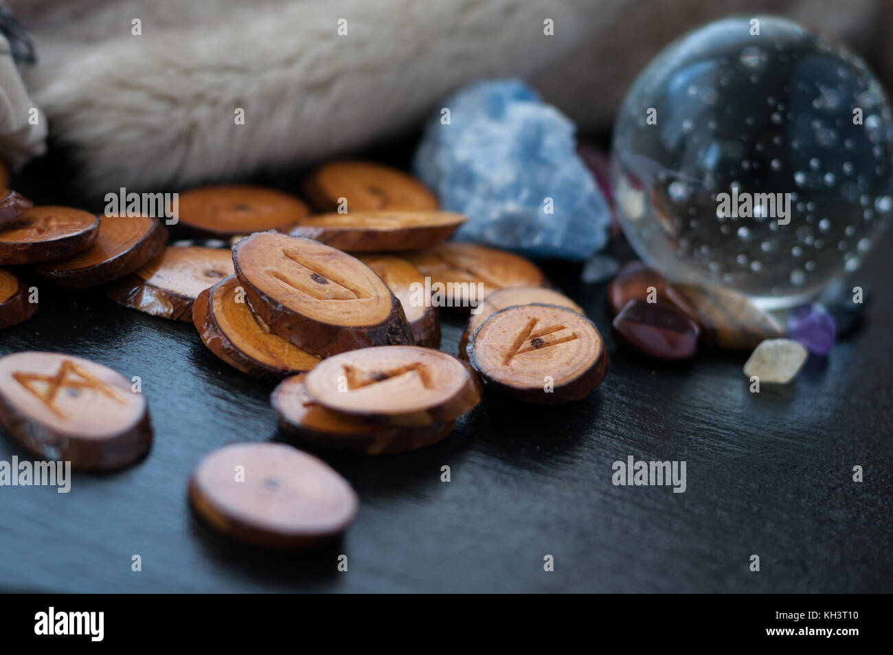 wood runes handmade fur are lying beside the crystal ball and semi ...