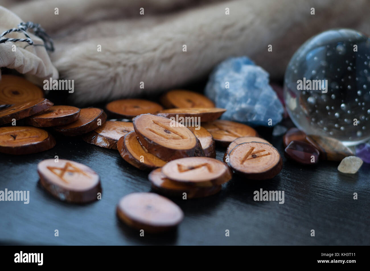 wood runes handmade fur are lying beside the crystal ball and semi ...
