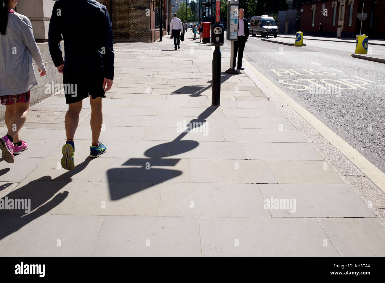 People walking on the pavement with sunshine and shadows Stock Photo ...