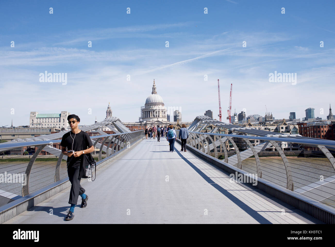 People walking across The Millennium Bridge in London Stock Photo - Alamy