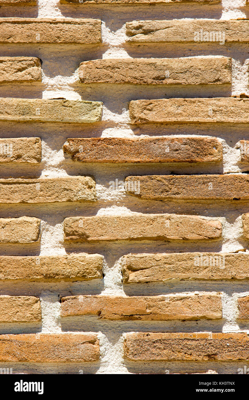 closeup of yellow bricks from clay build a wall with white concrete ...