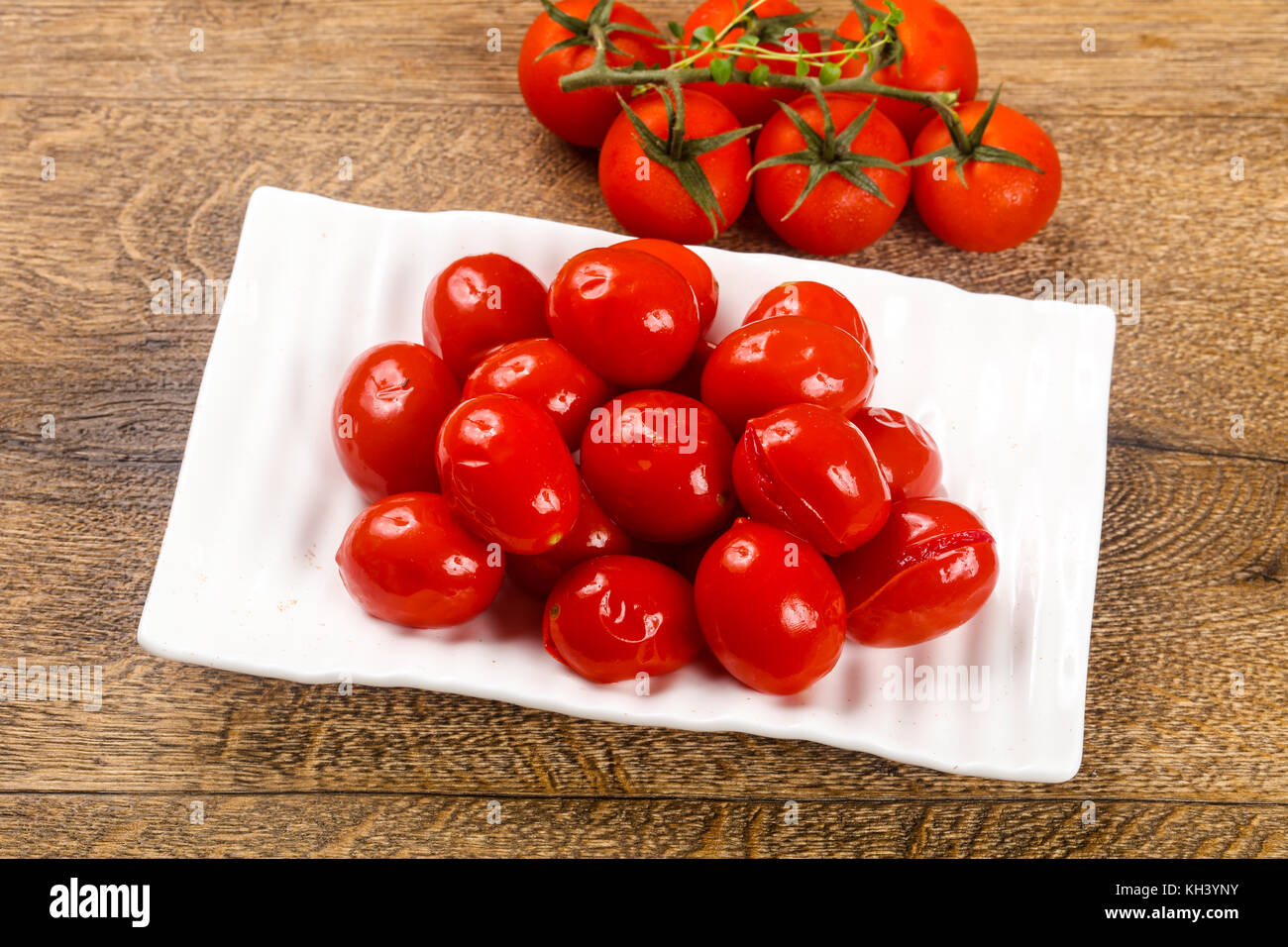 Pickled cherry tomatoes heap on the wooden background Stock Photo - Alamy