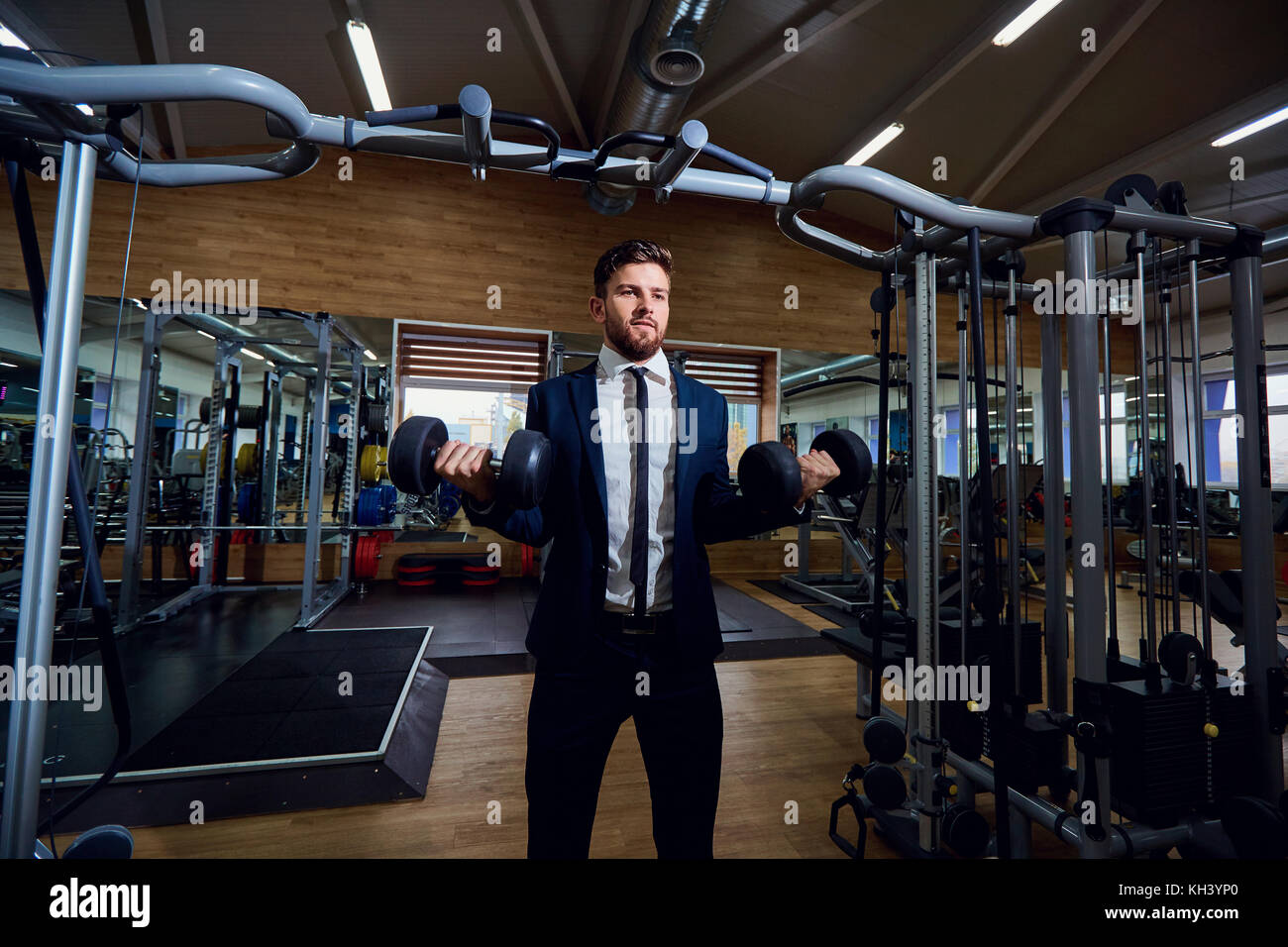 Businessman doing exercises with dumbbells in the gym Stock Photo - Alamy