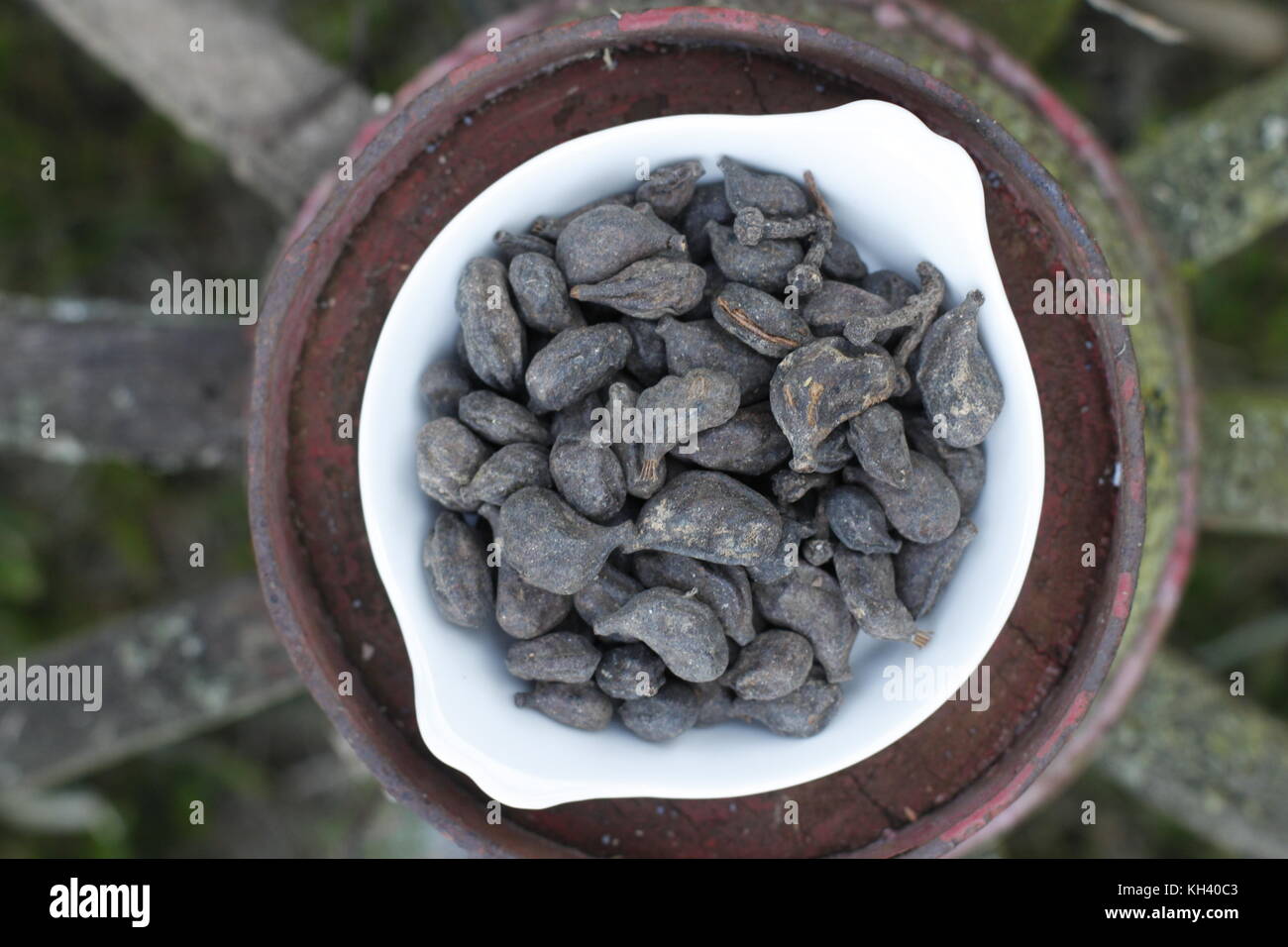 Whole negro pepper in white bowl on rustic background with wood and ...