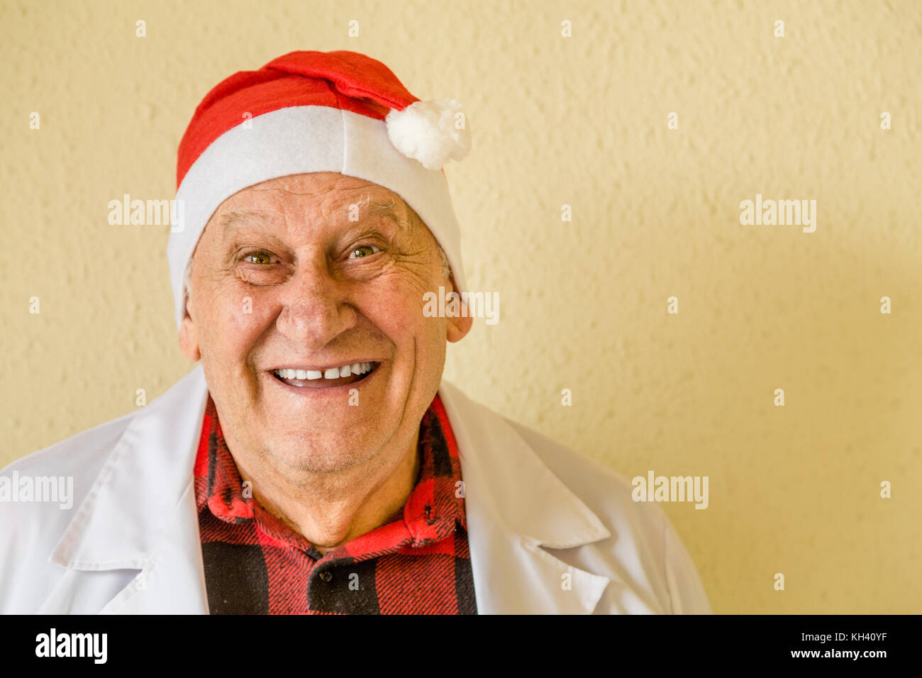 old doctor with white medical gown and checkered shirt smiling and ...