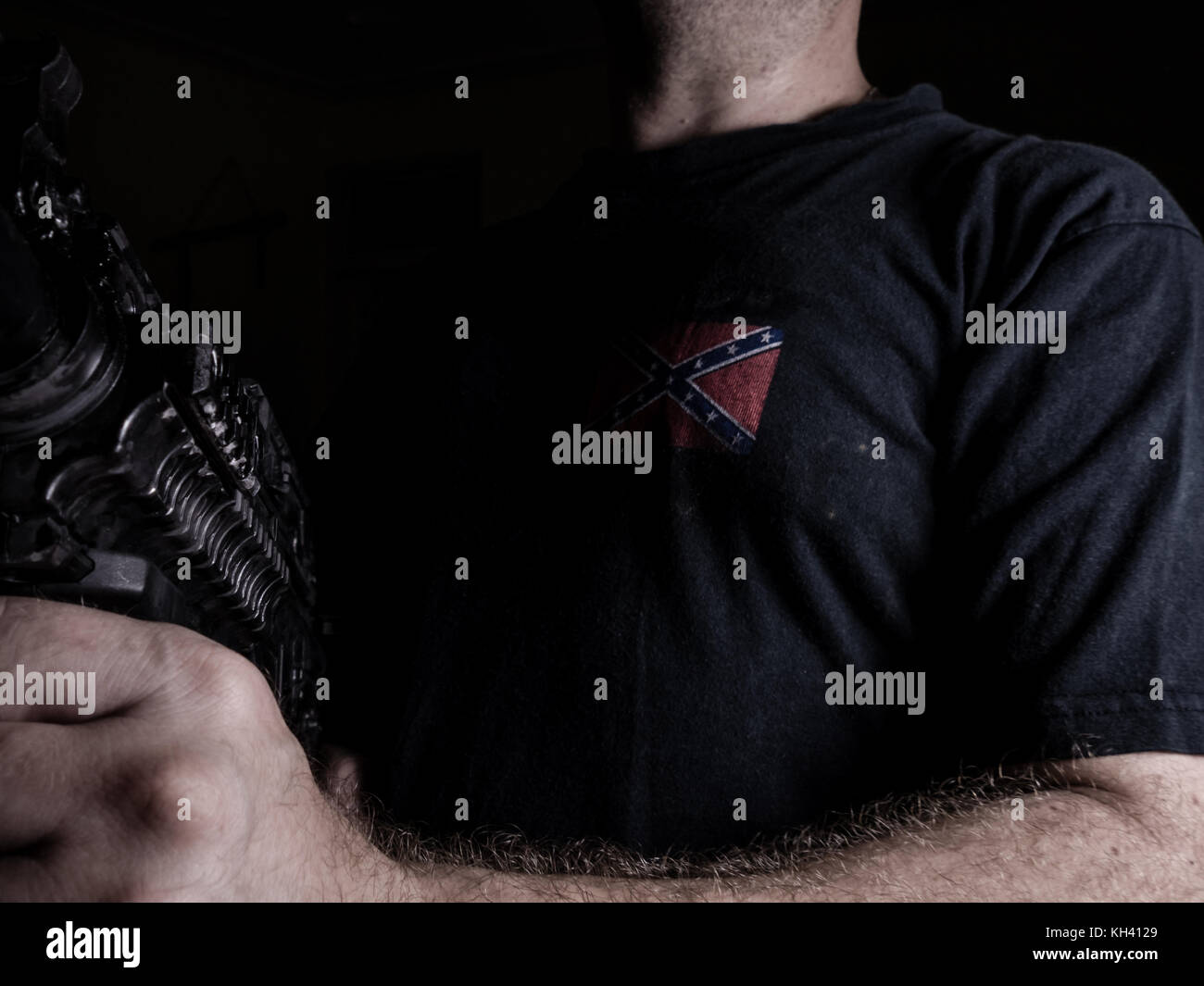 Anonymous man wearing confederate flag t-shirt holding assault rifle ...