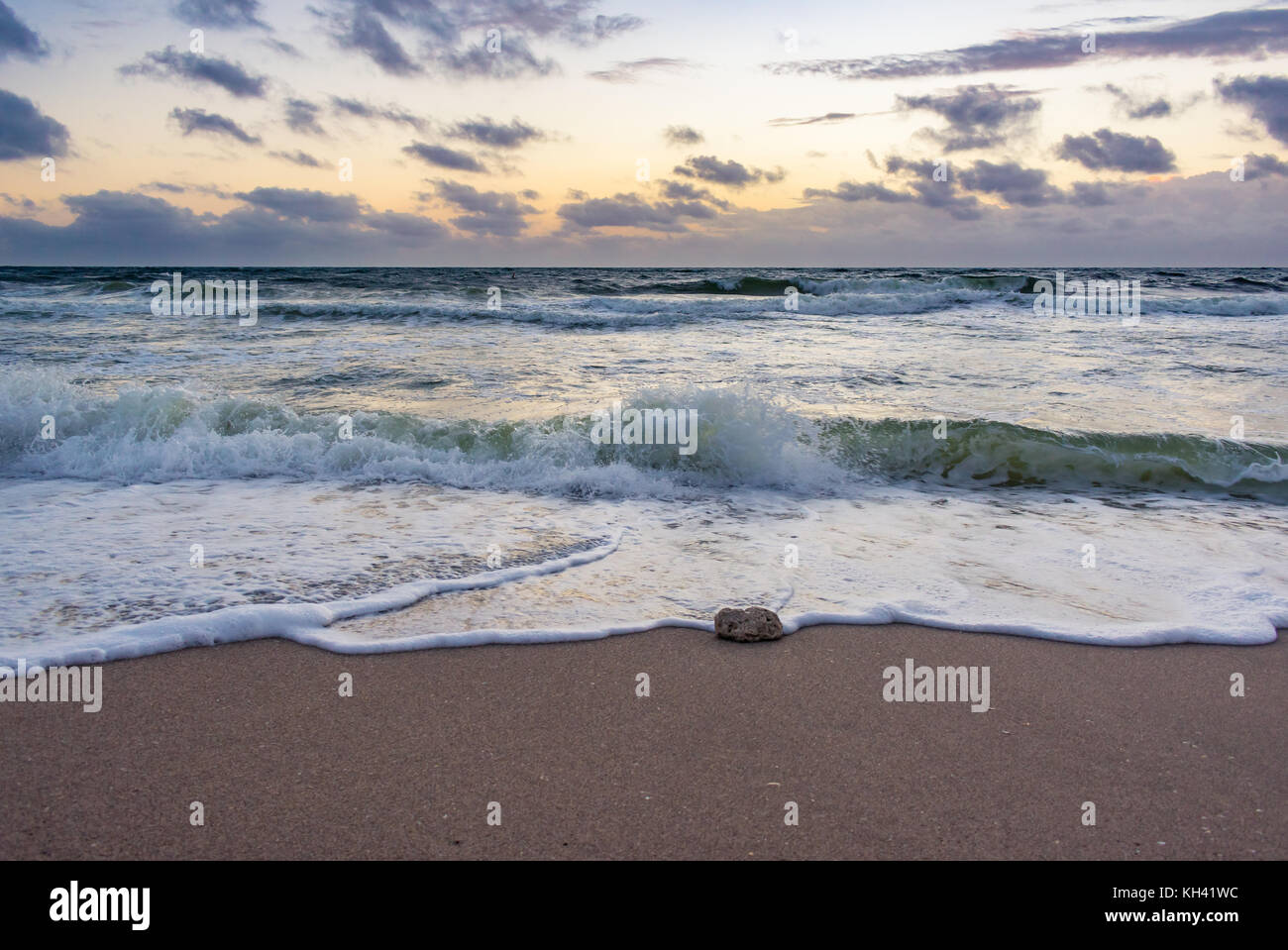 path between sand dunes leading towards the beach on a warm morning ...