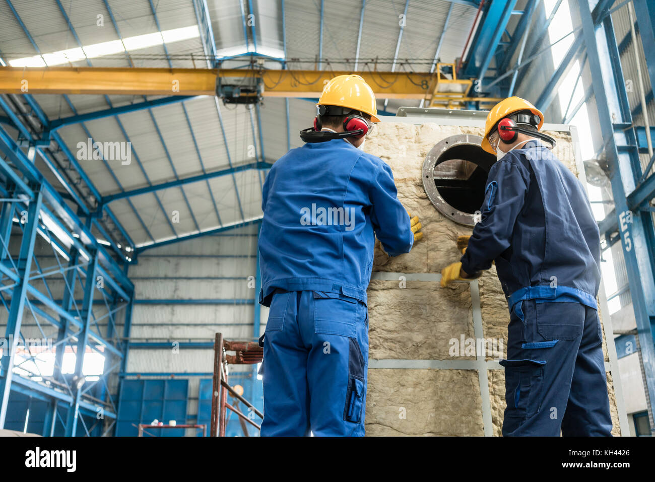 Workers applying insulation material to an industrial boiler Stock ...