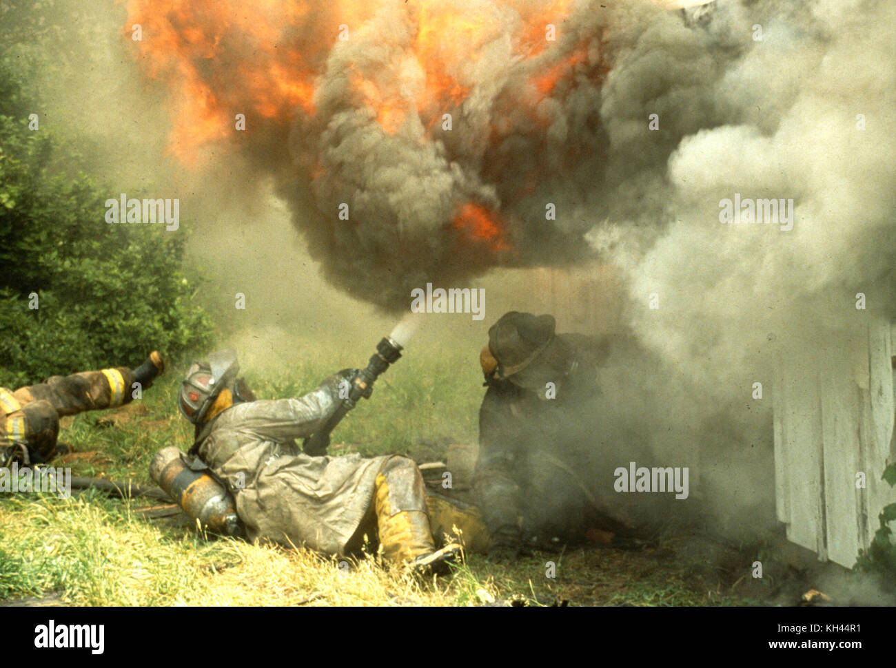 Firefighter ducks a fireball coming from a back-draft during a house ...
