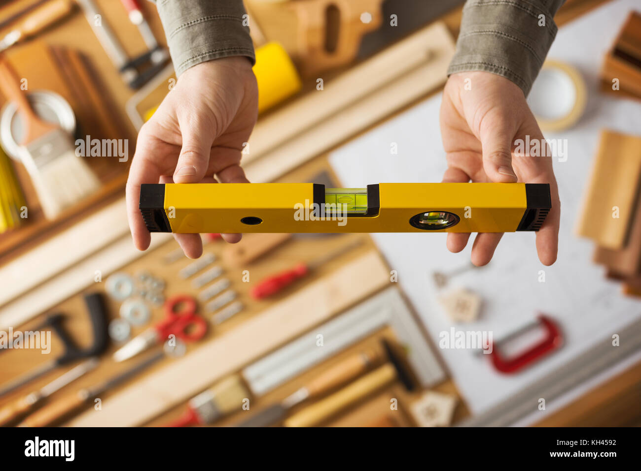 Male hands holding a level, work table with construction and repair ...